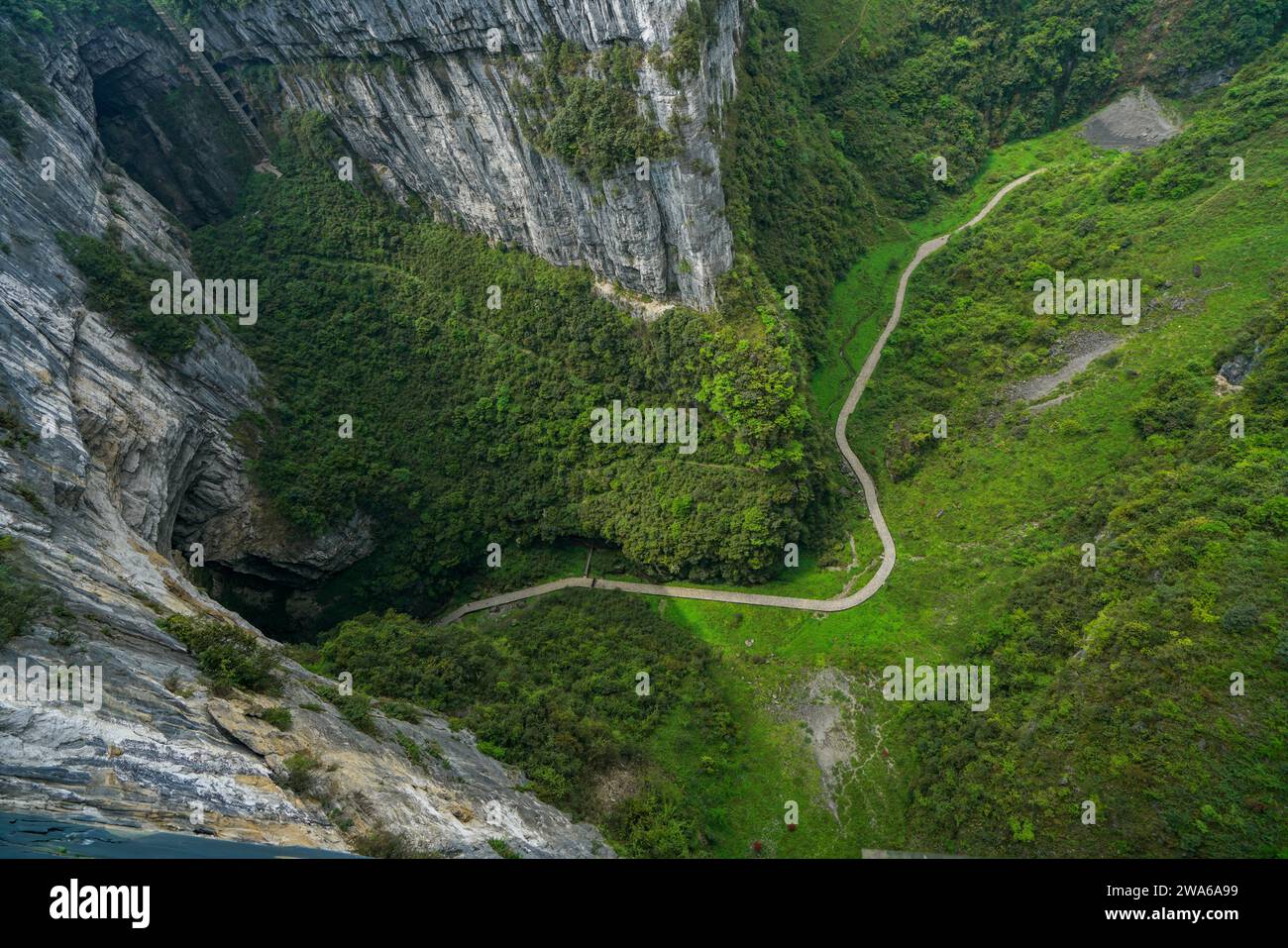 There is a path in the lush green valley. The Three Natural Bridges are ...