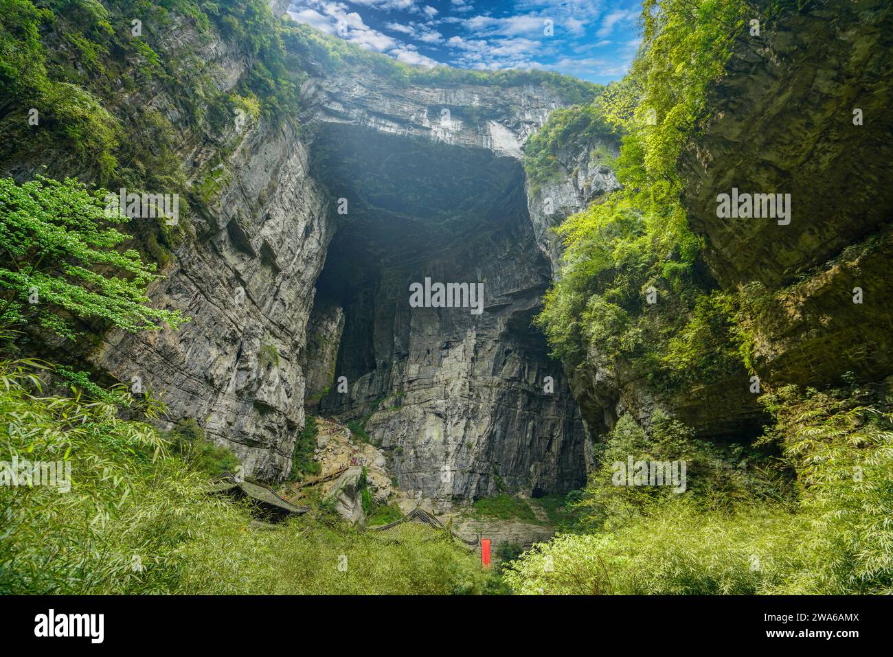 The sky is a natural opening in the roof of the rock pit. Lush green ...