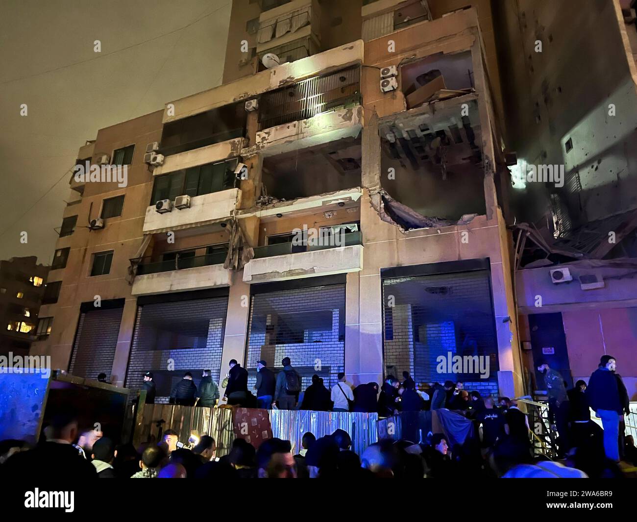 People stand outside a building after an explosion in southern Beirut ...