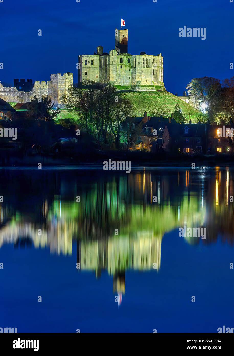 View at dusk of Warkworth Castle and Warkworth village reflected in the ...