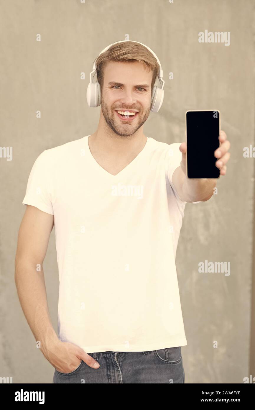 happy man presenting music app, copy space. man presenting music app ...