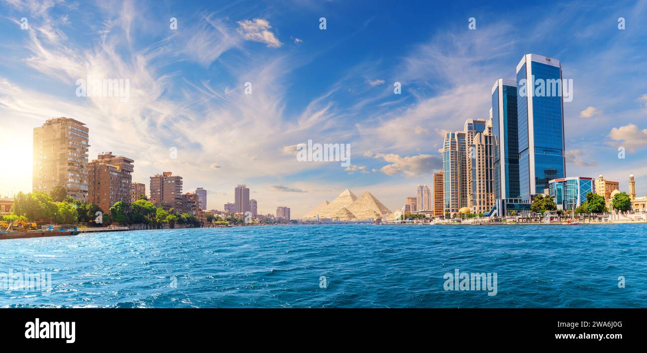 Unique panorama of the Nile river, modern buildings and famous Pyramids ...