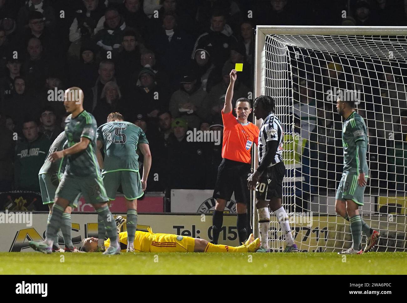 Referee David Munro shows a yellow card to St Mirren's Toyosi Olusanya ...