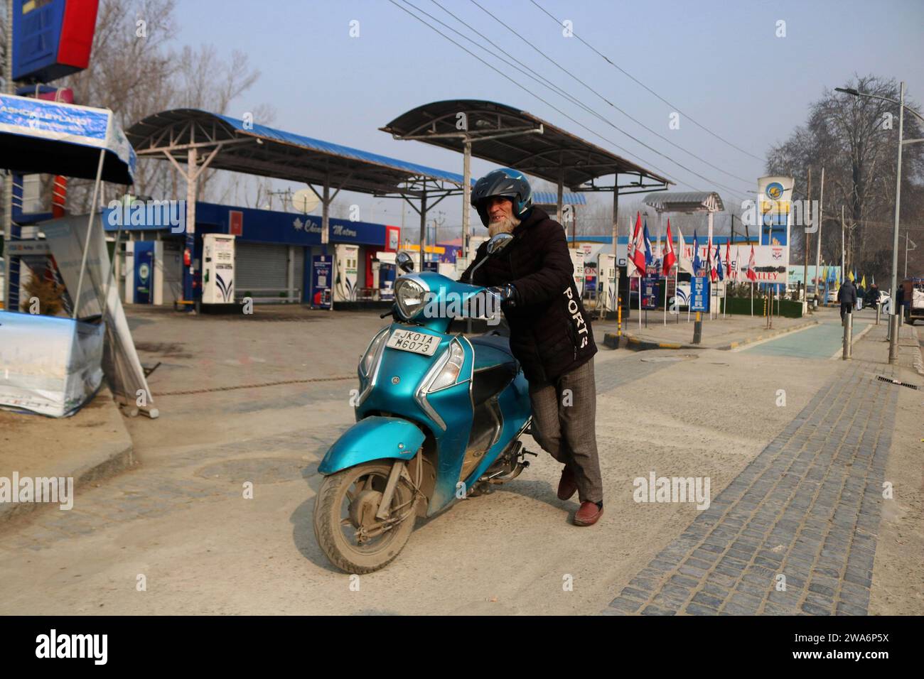 January 02,2024, Srinagar Kashmir, India : A man pushes his scooty past closed petrol filling ...