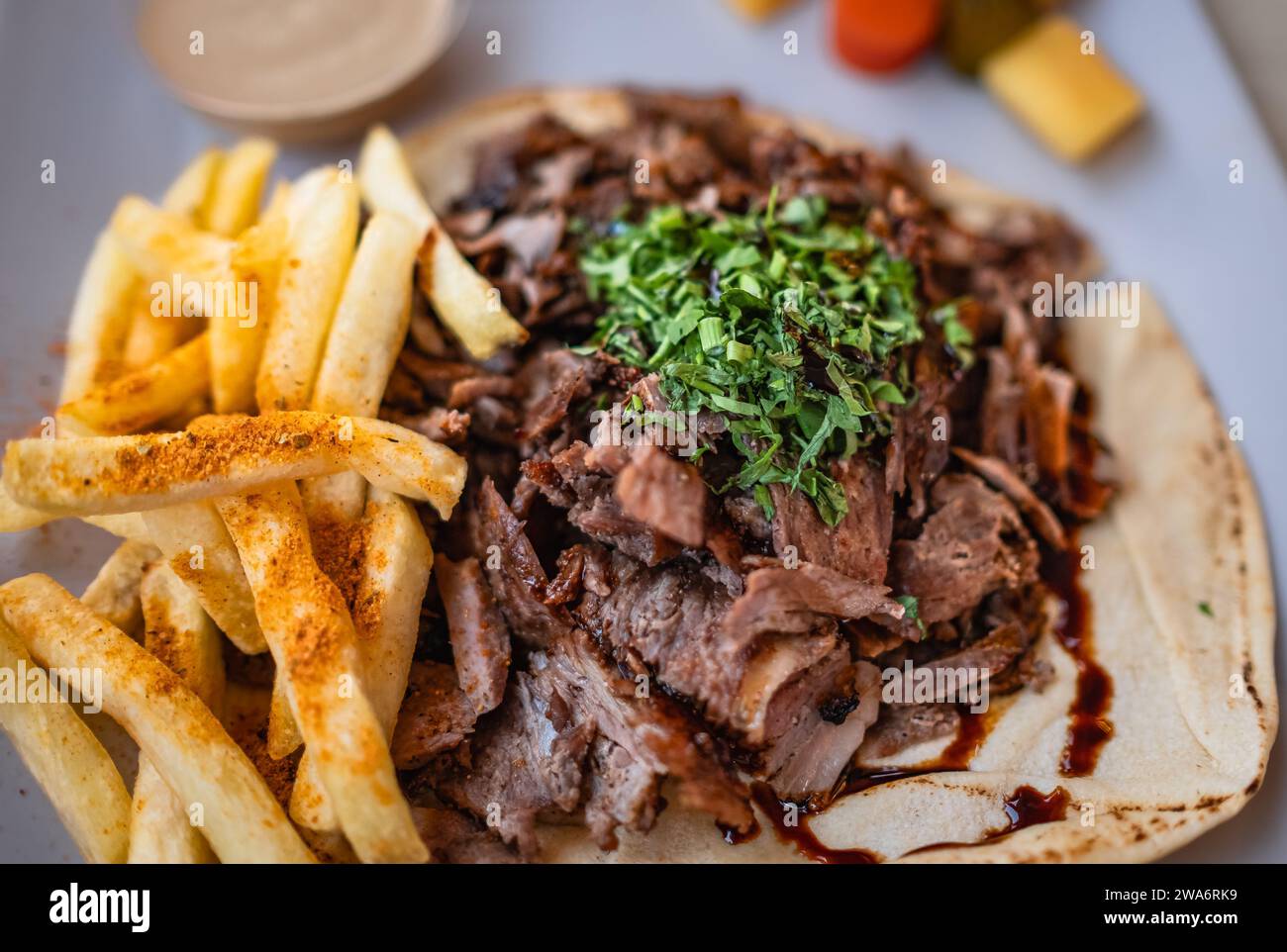 Doner Kebab on plate with fries and grilled meat on plate. Fried meat ...