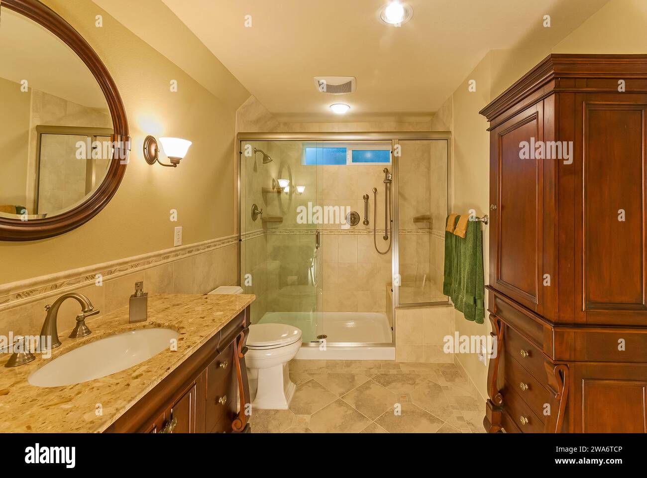 Remodeled bathroom in a middle-class home. A piece of wooden furniture ...