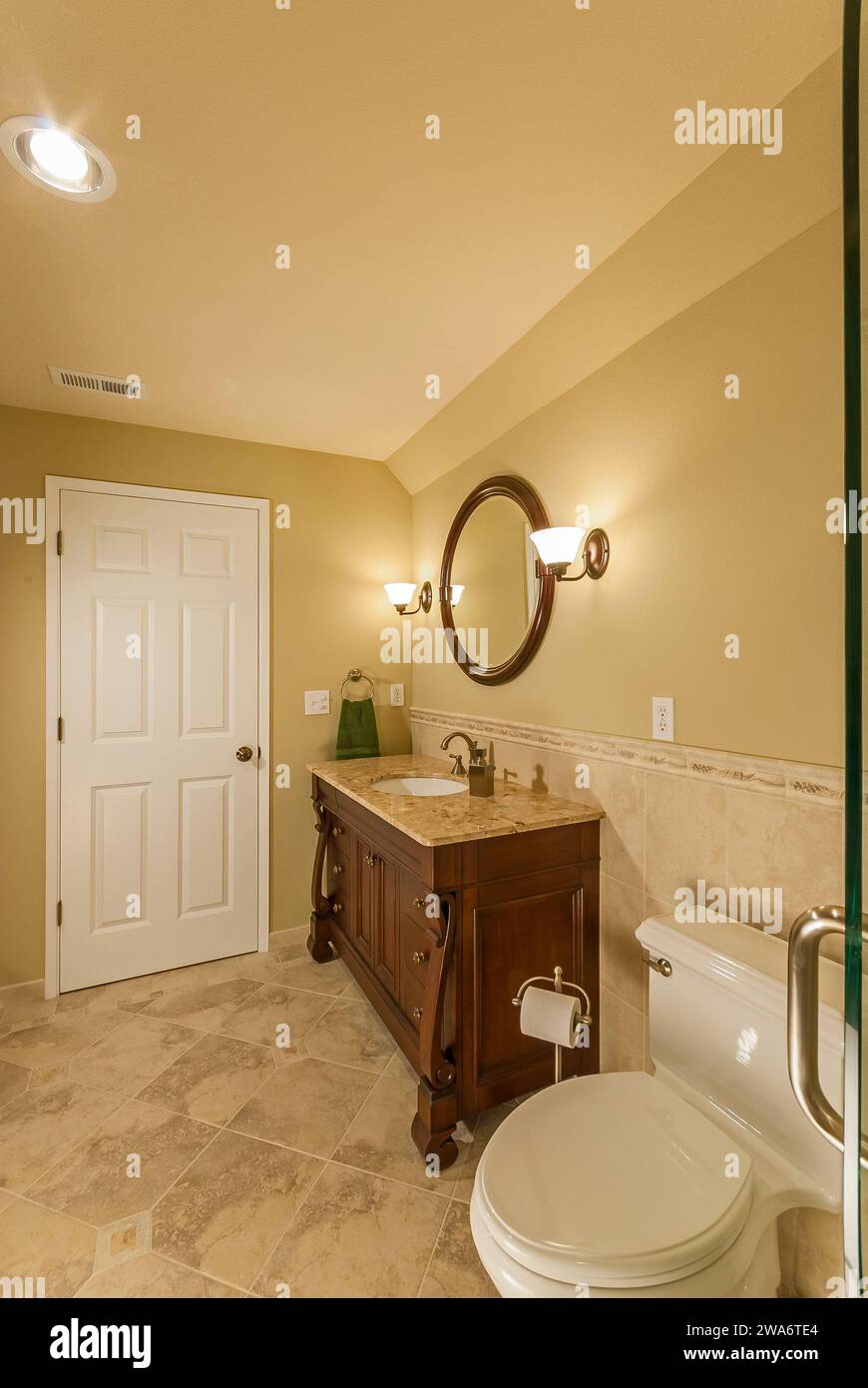 Remodeled bathroom in a middle-class home. A piece of wooden furniture ...