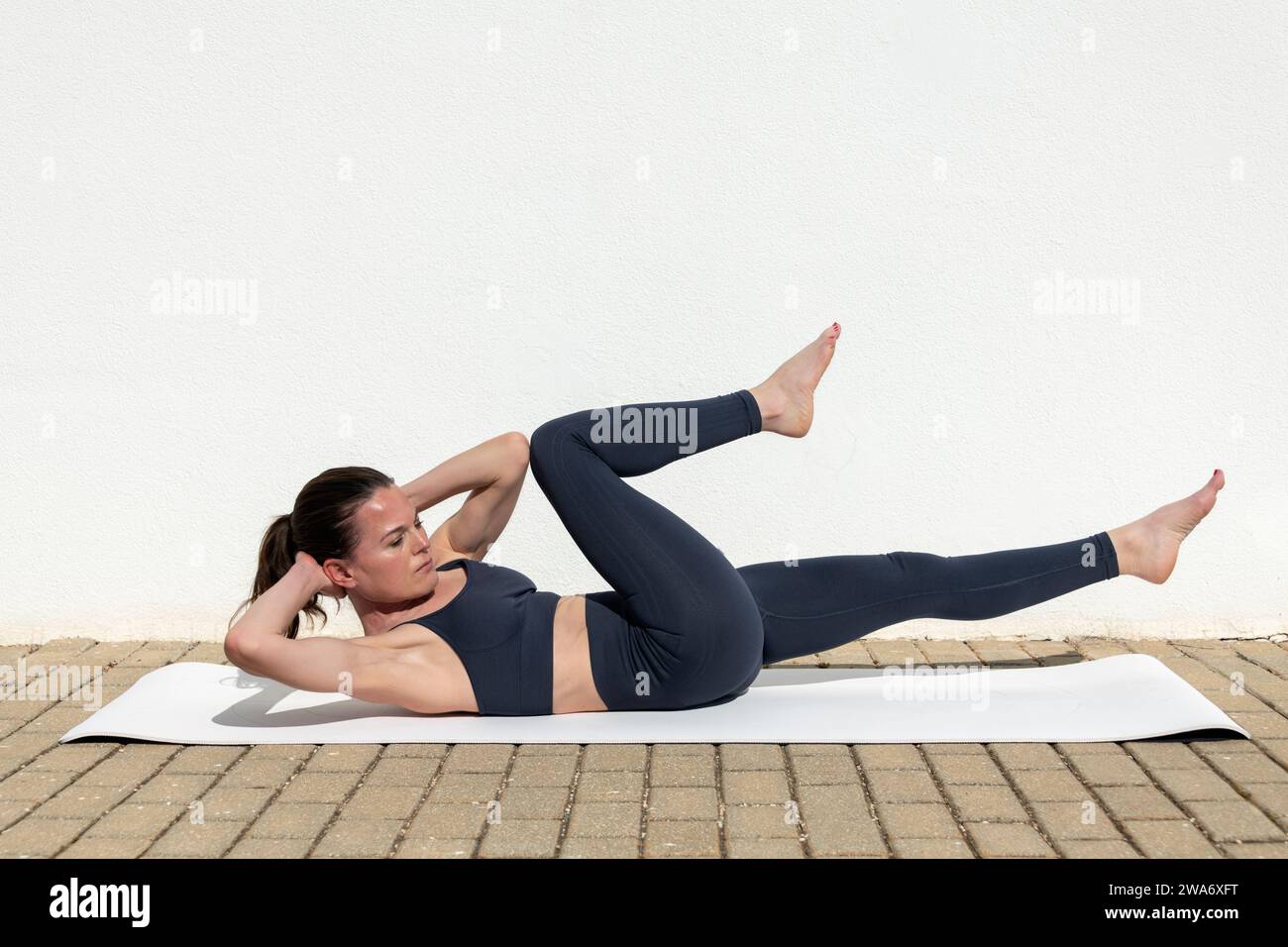 Fit, sporty woman doing bicycle crunch workout to improve her abominal ...