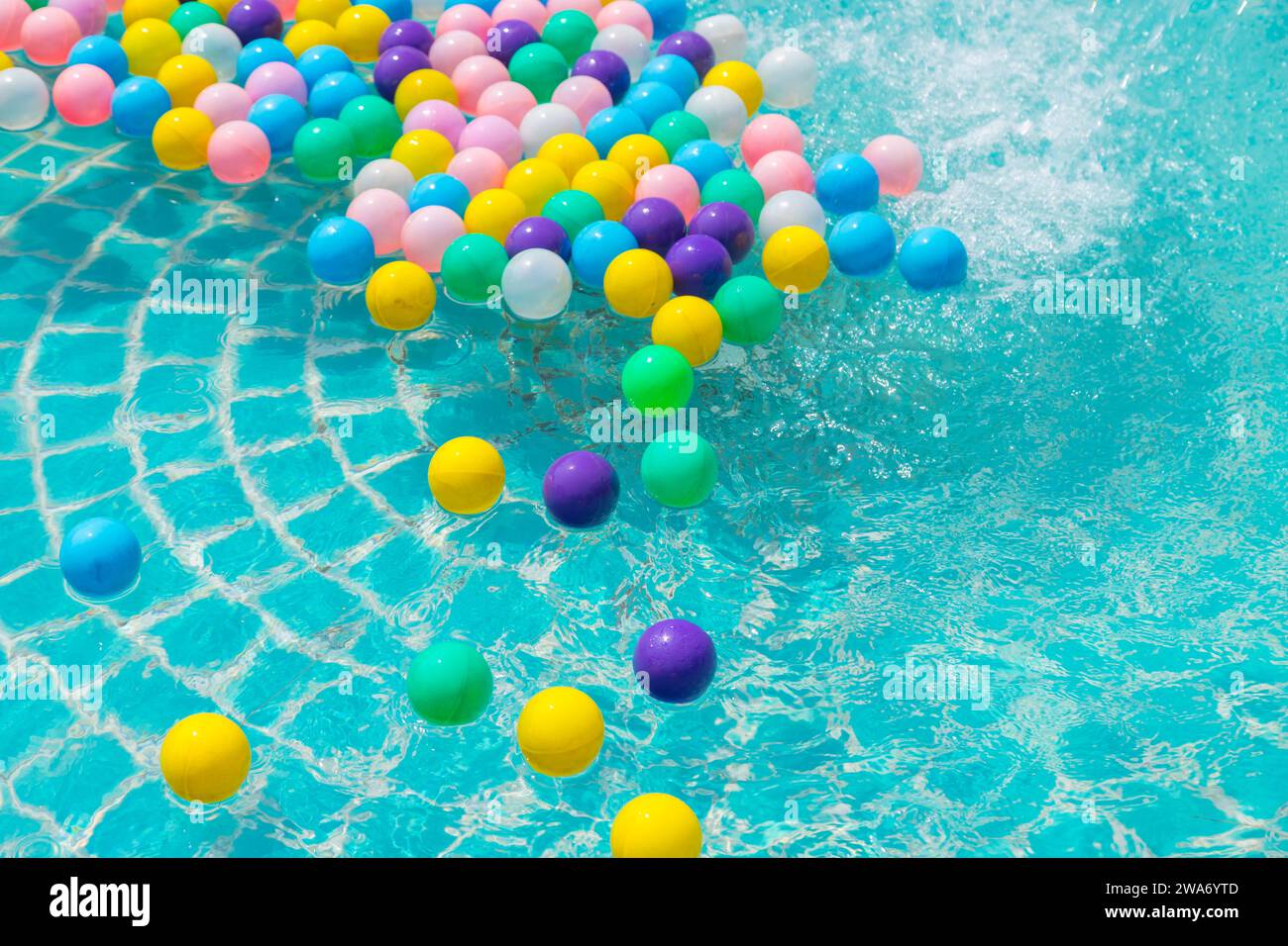 Colorful balls in the swimming pool reflecting the turquoise light ...