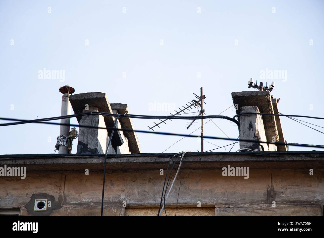 The roof of an old residential building with antennas and a chimney and ...