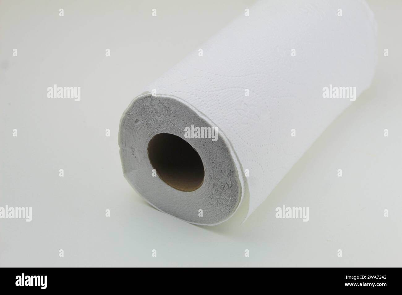 A close up photo of a white kitchen paper towel roll on its side on a ...