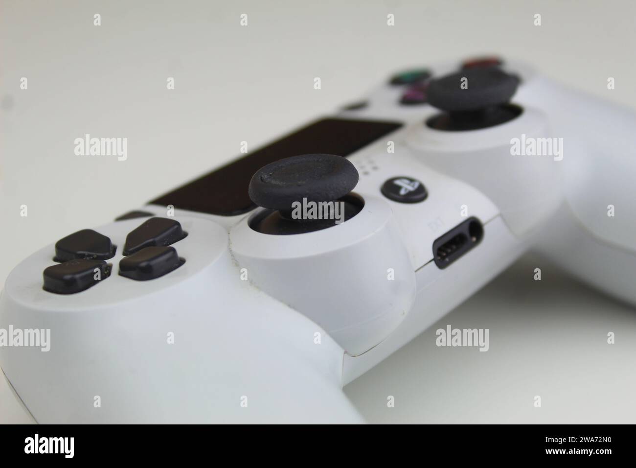 A close up photo of a white Sony DualShock 4 V2 Playsation 4 controller ...