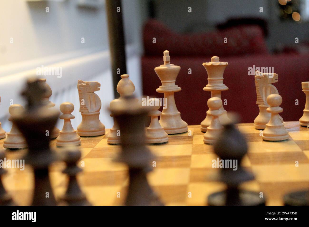A close up photo of a handmade wooden chess board and chess pieces ...