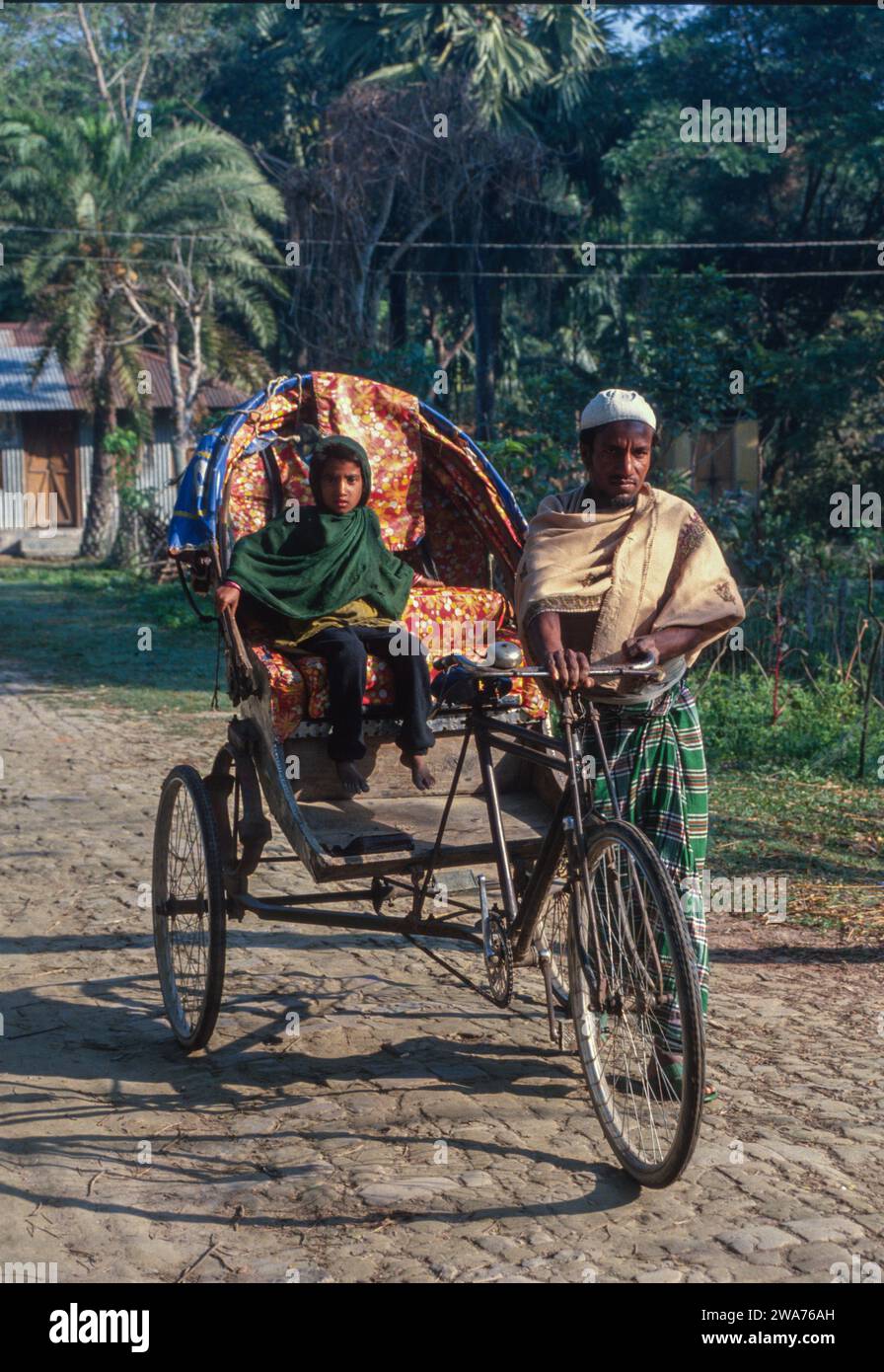 Rickshaw driver and girl passenger in a village in the Sundabarns ...