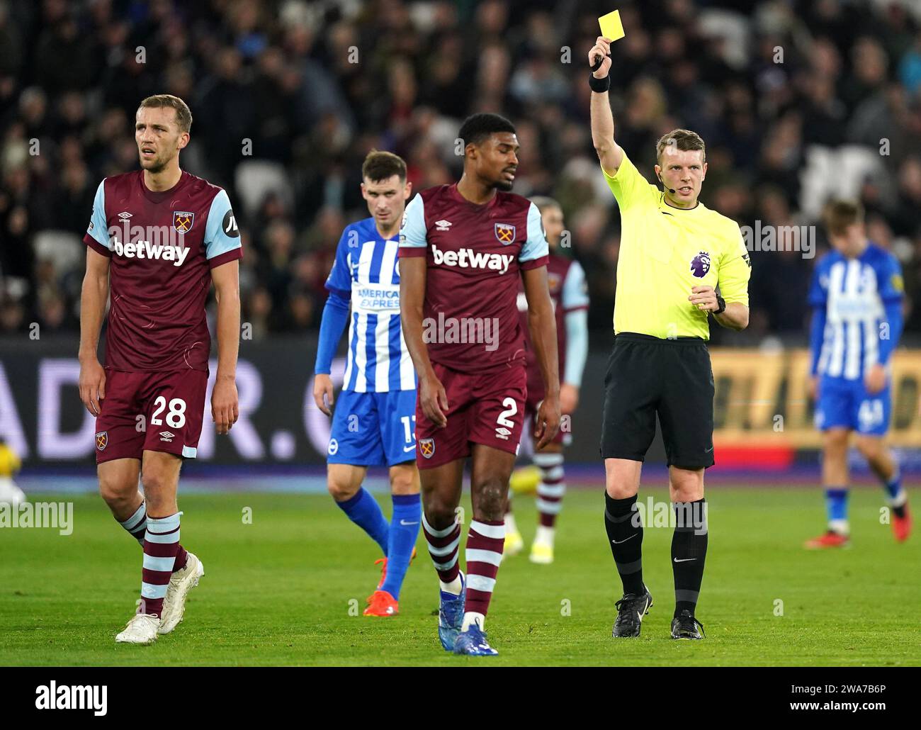 Referee Sam Barrott (right) shows a yellow card to West Ham United's ...