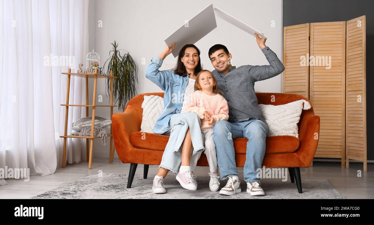 Happy family with cardboard dreaming about their new house at home ...