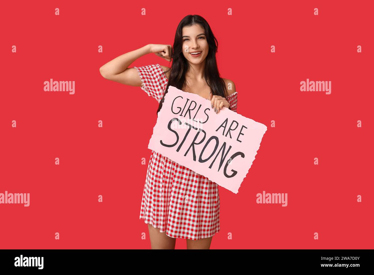 Young woman holding sign with text GIRLS ARE STRONG and flexing muscles ...