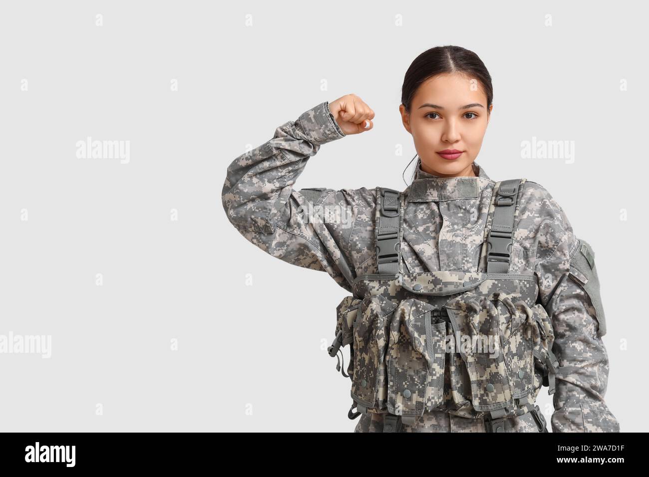Young female soldier flexing muscles on white background. Feminism ...