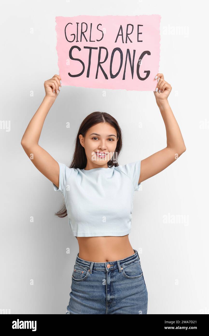 Young woman with sign GIRLS ARE STRONG on white background. Feminism ...