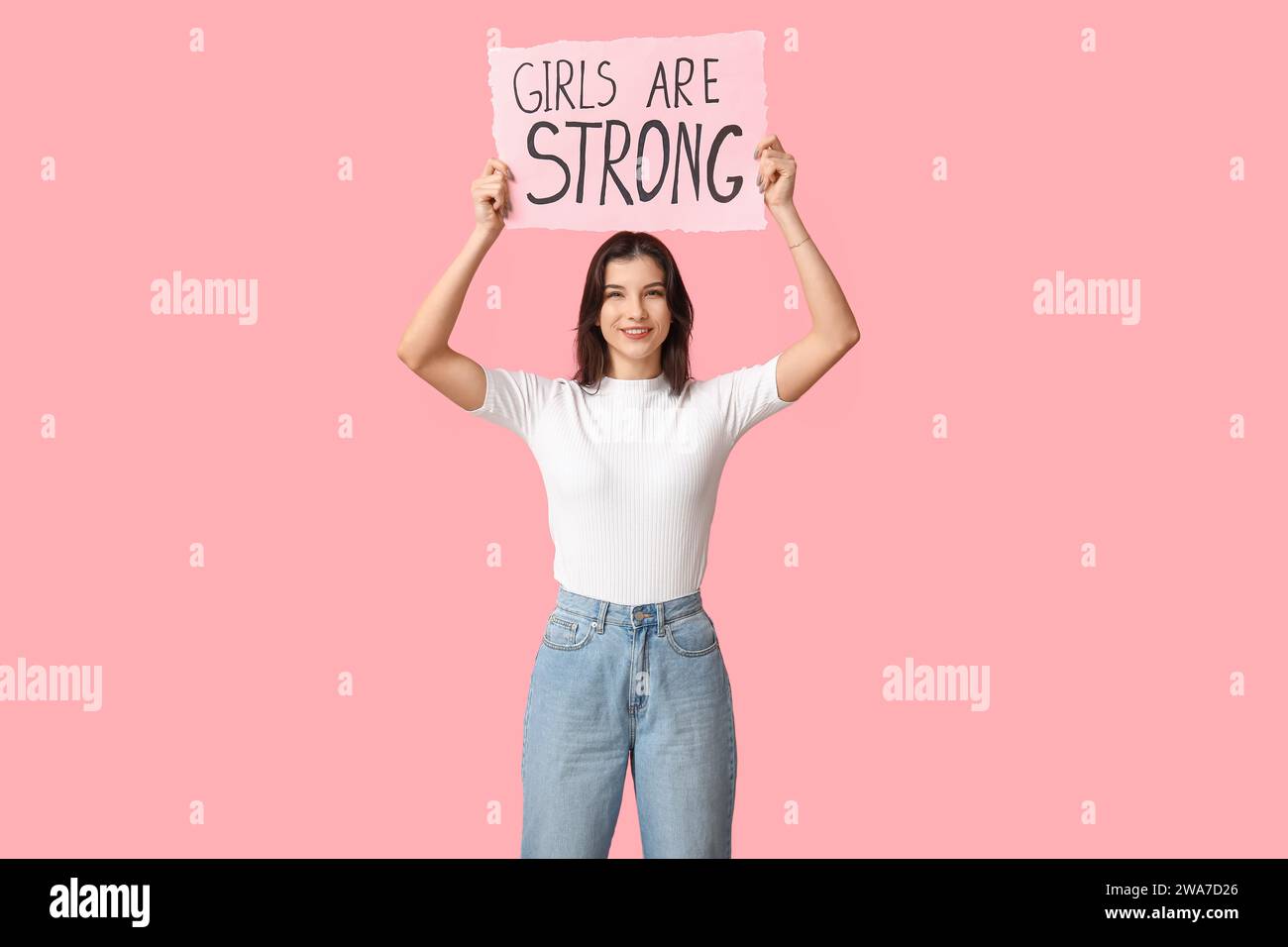 Young woman with sign GIRLS ARE STRONG on pink background. Feminism ...