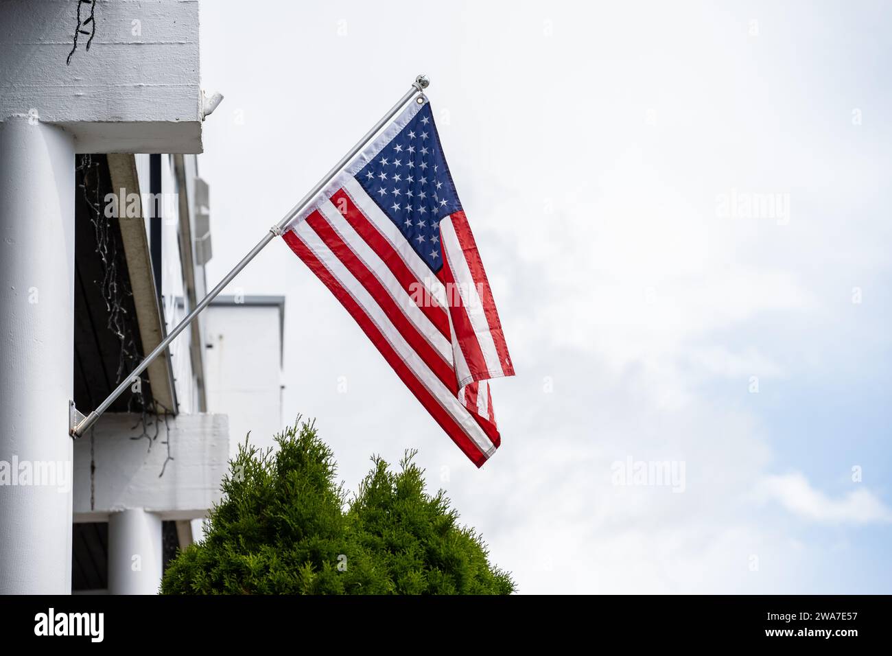 American flag hanging from a flag pole on a facade Stock Photo - Alamy