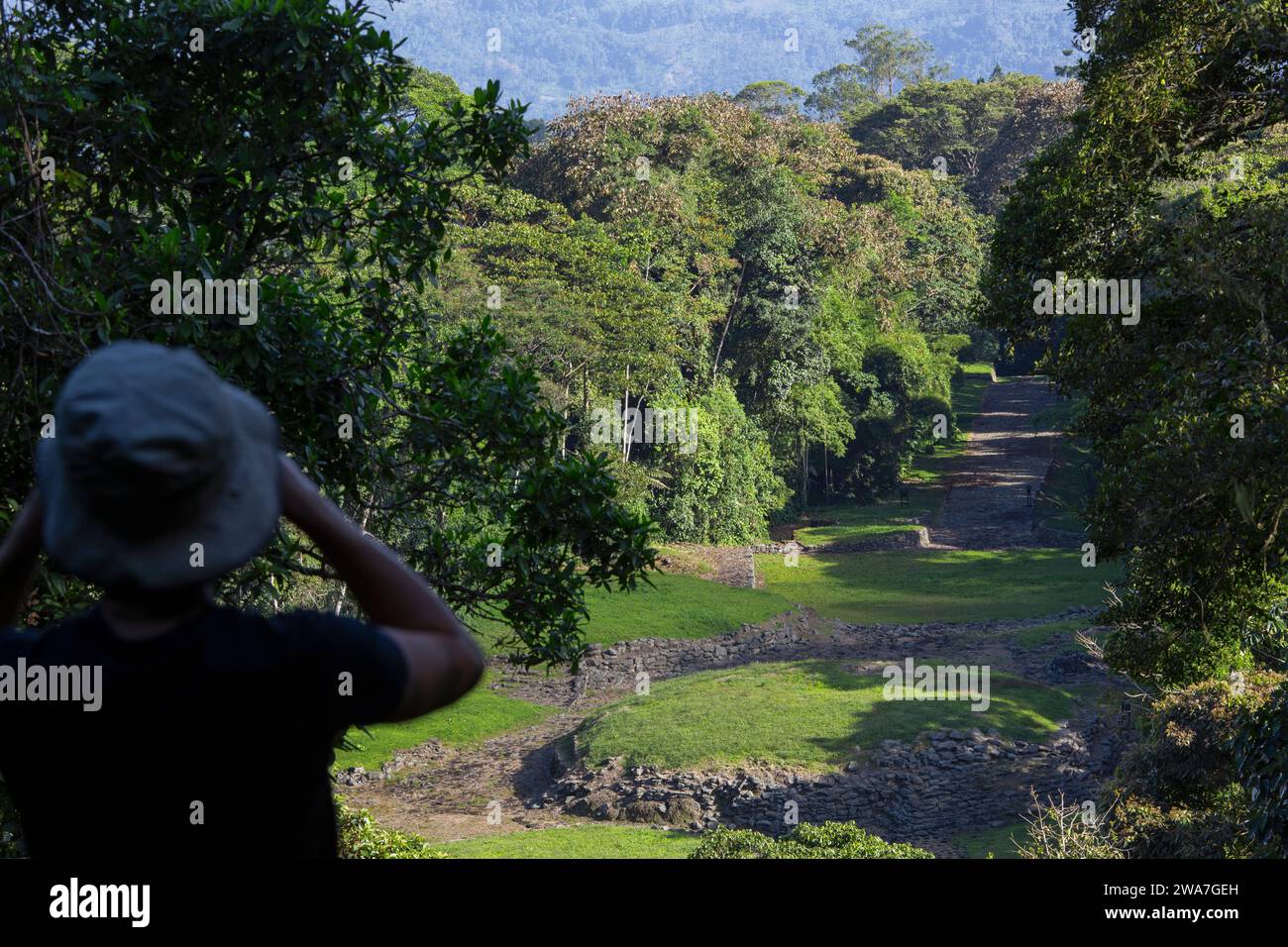 Tourist looking at Central Mound and Calzada Caragra cobblestone road ...