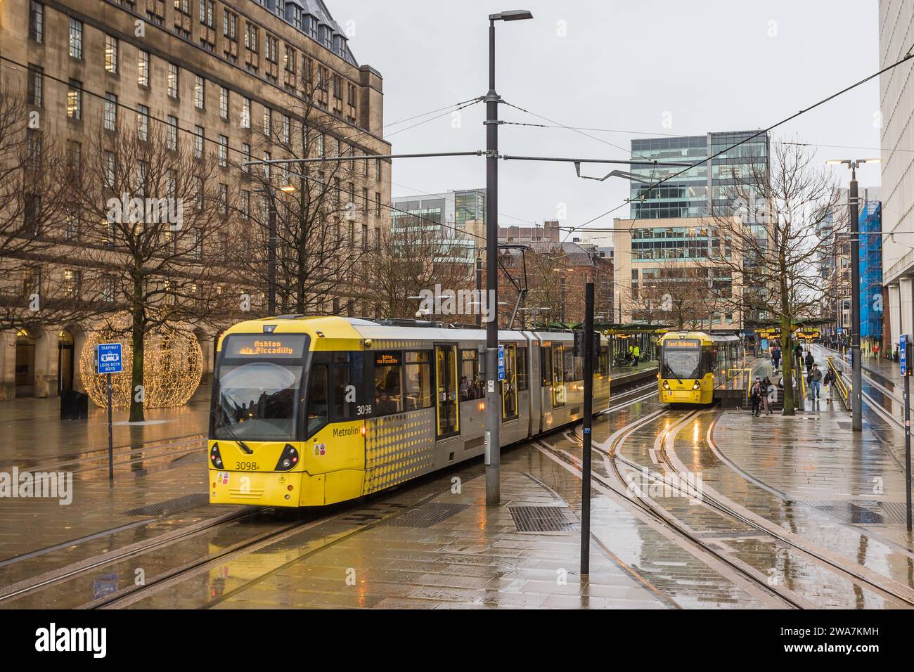 A pair of trams pass one another in the rain at St Peters Square ...