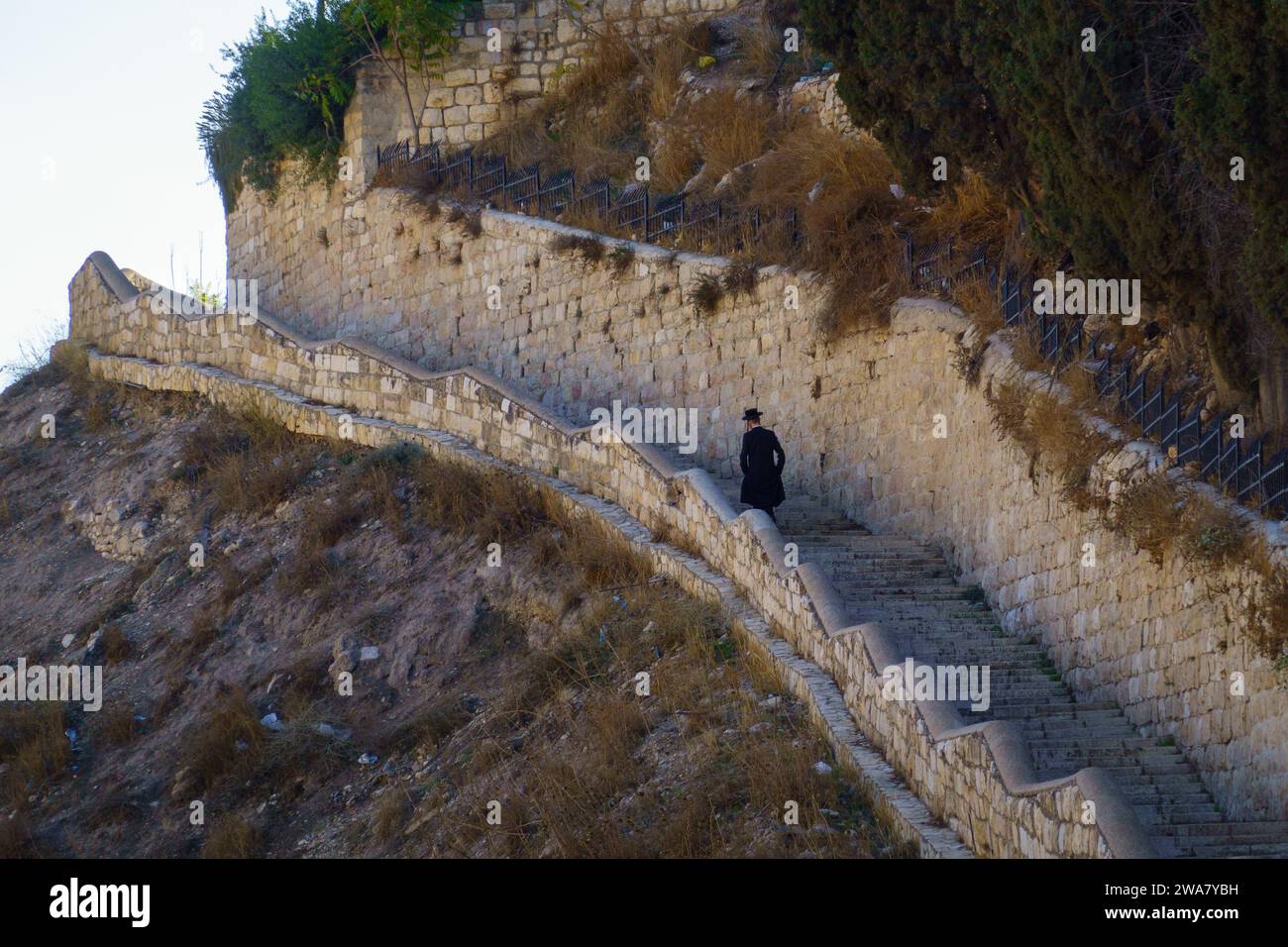 Orthodox Jew in traditional attire descends ancient stone steps in ...