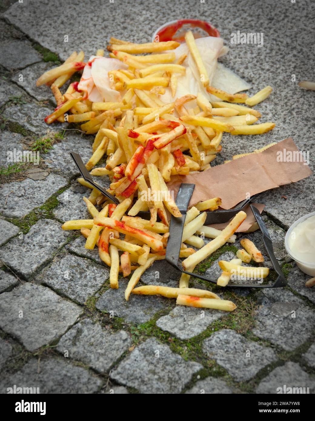 French fries with ketchup. Pommes frites spilled on the sidewalk ...