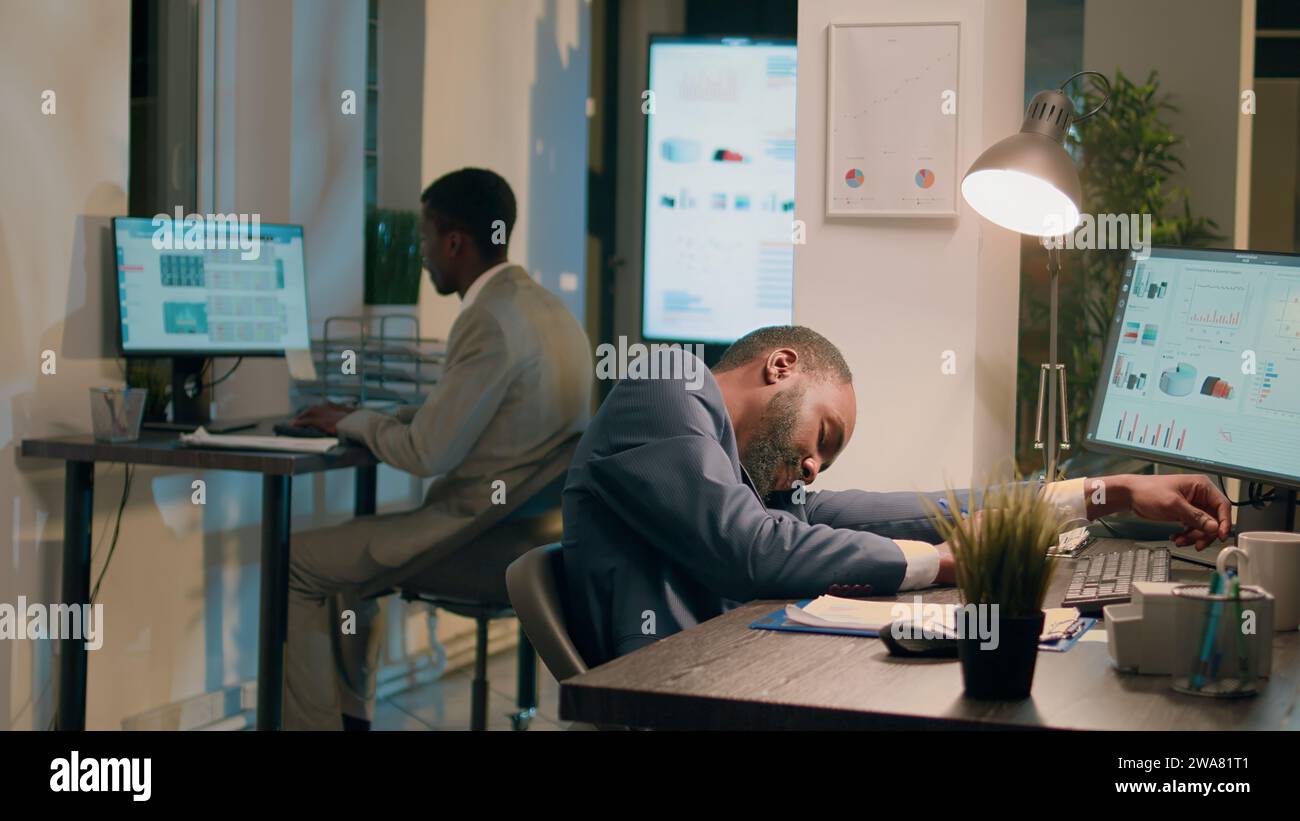 Drowsy accountant sleeping in office, being woken up by colleague ...