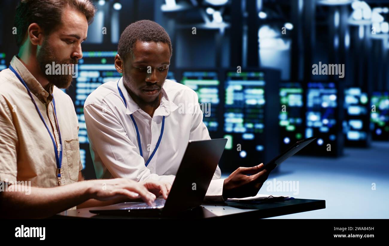 Teamworking experts doing maintenance on servers helping businesses ...