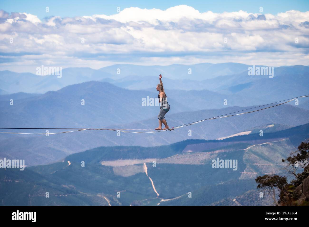 Slacklining across the Australian Alps. A slackliner balancing high at ...