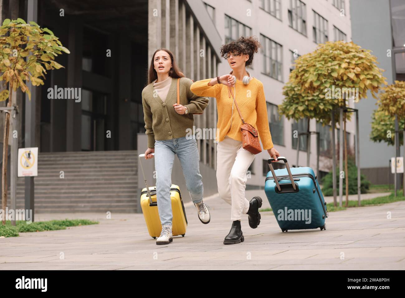 Being late. Worried women with suitcases running outdoors Stock Photo ...