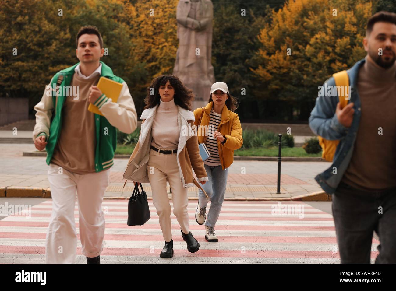 Being late. Group of students running on pedestrian crossing outdoors ...