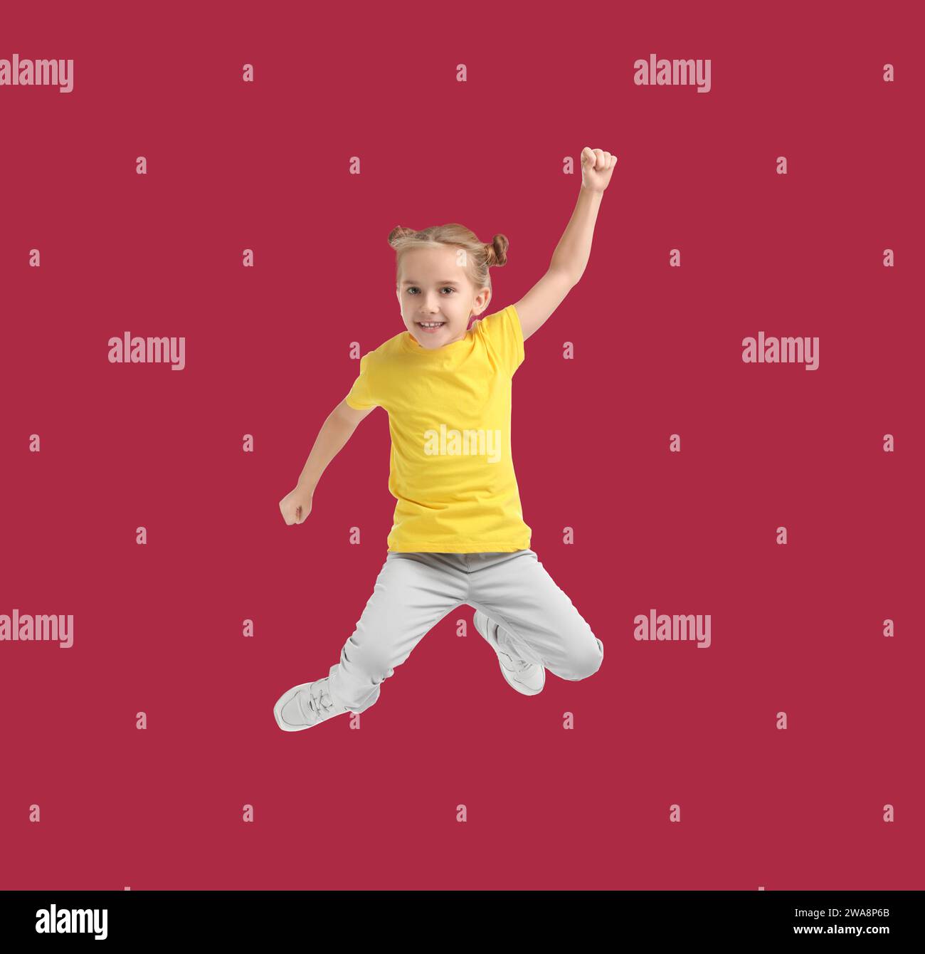 Happy cute girl jumping on red background Stock Photo - Alamy
