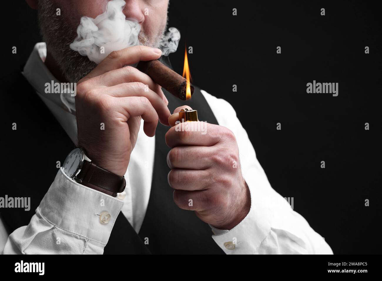 Man lighting cigar on black background, closeup. Space for text Stock ...
