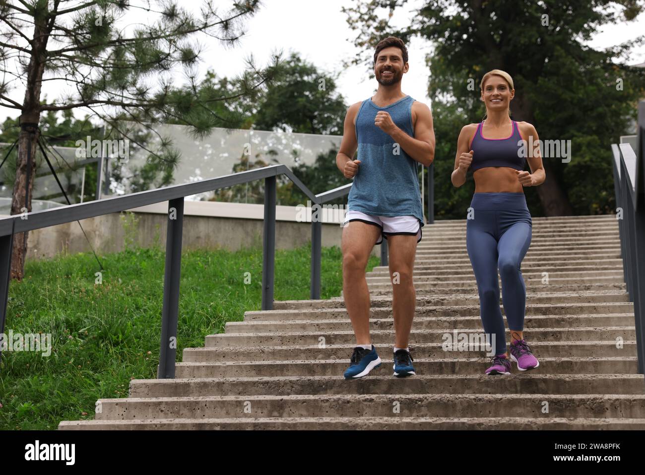 Healthy lifestyle. Happy couple running down stairs outdoors Stock ...