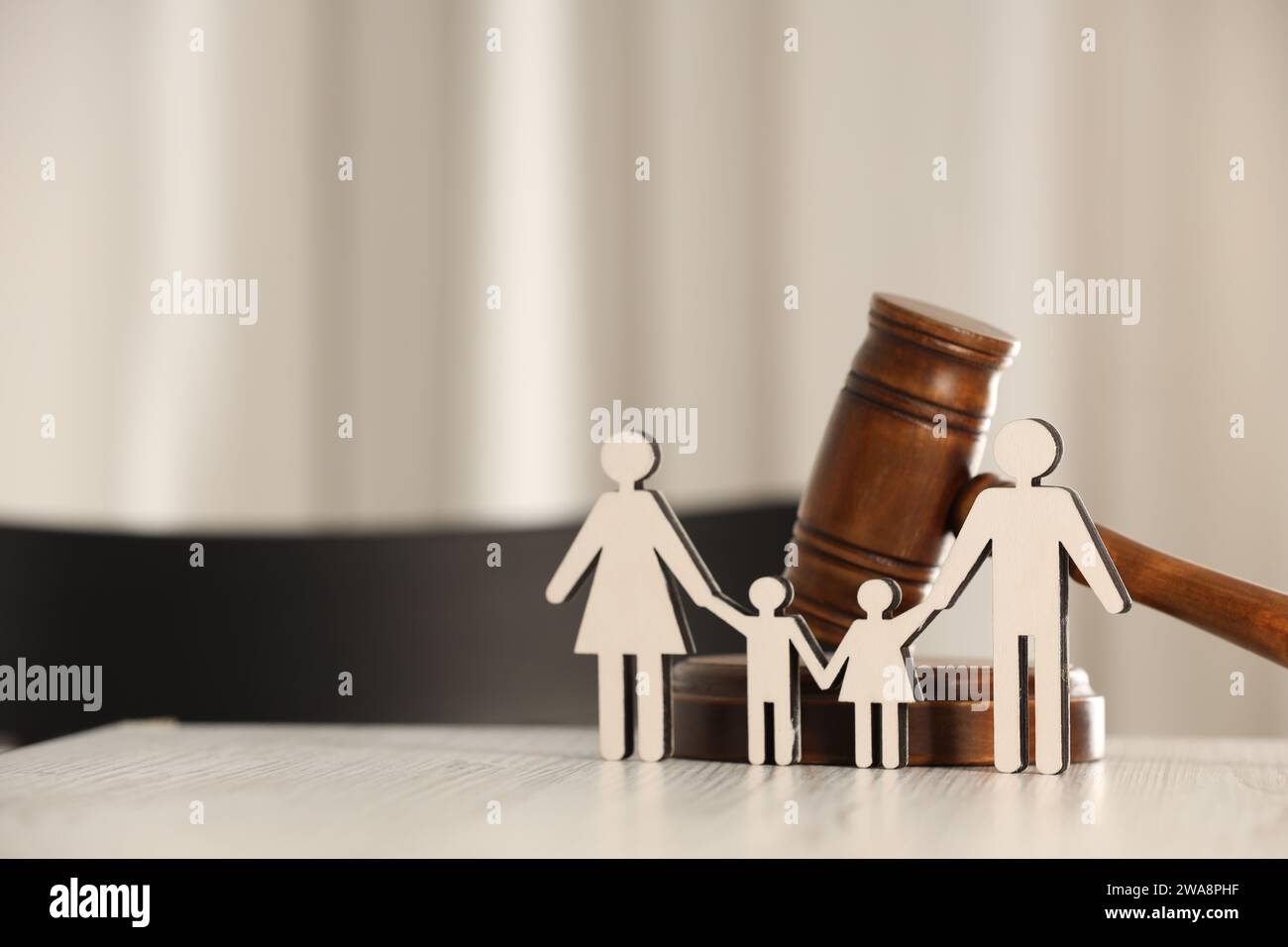 Law concept. Gavel and figures of parents with children on white wooden ...