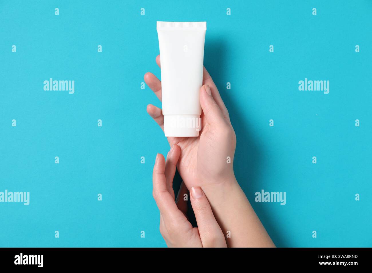 Woman with tube of hand cream on light blue background, top view Stock ...