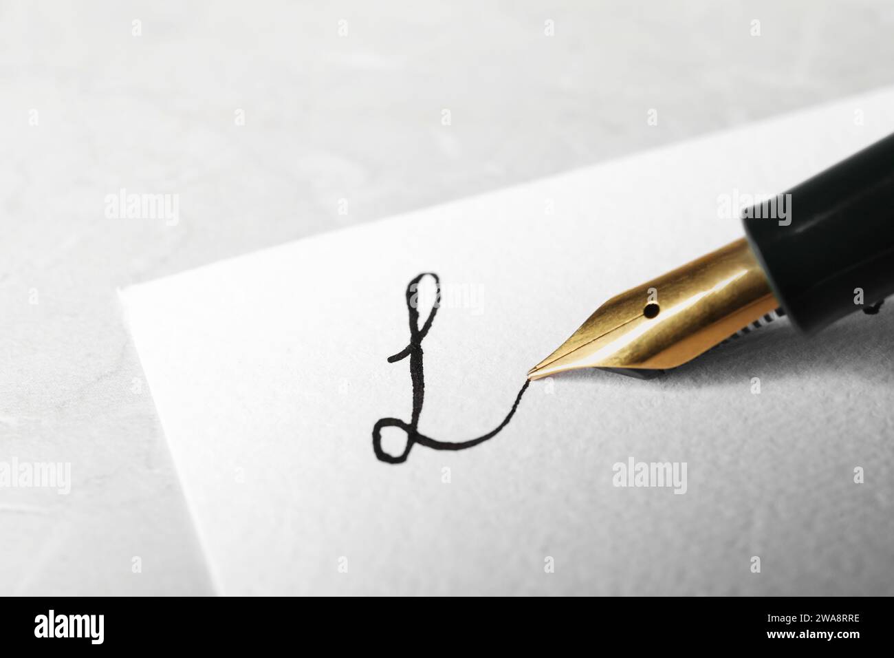 Signing on sheet of paper with fountain pen at gray table, closeup ...