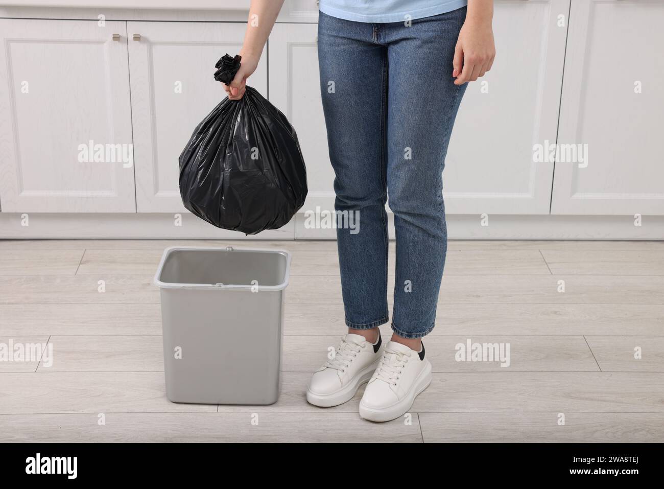 Woman taking garbage bag out of trash bin in kitchen, closeup Stock ...
