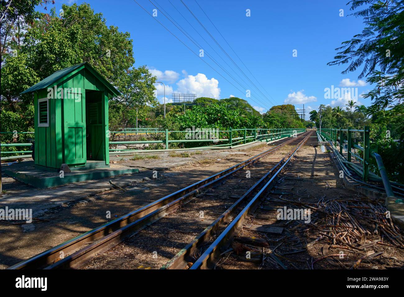A green hut stands next to railway tracks on a bridge surrounded by ...