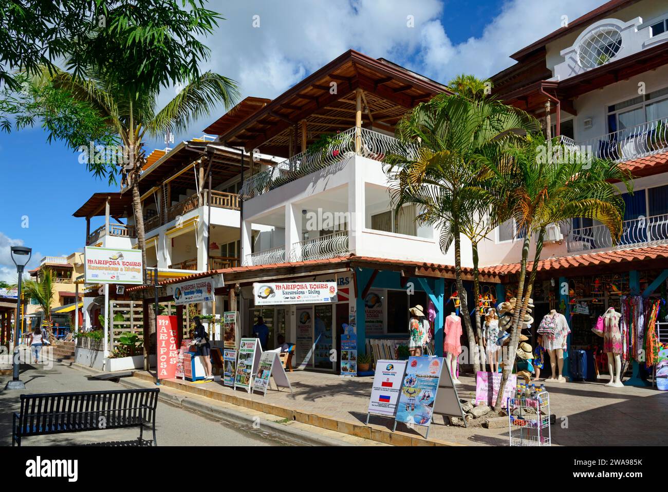 A lively street scene in a tropical town with wooden architecture and ...