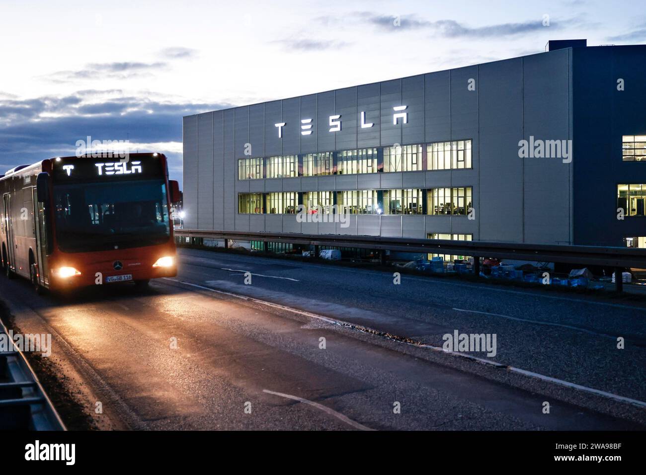 The Tesla bus drives past the battery factory of the Tesla plant ...