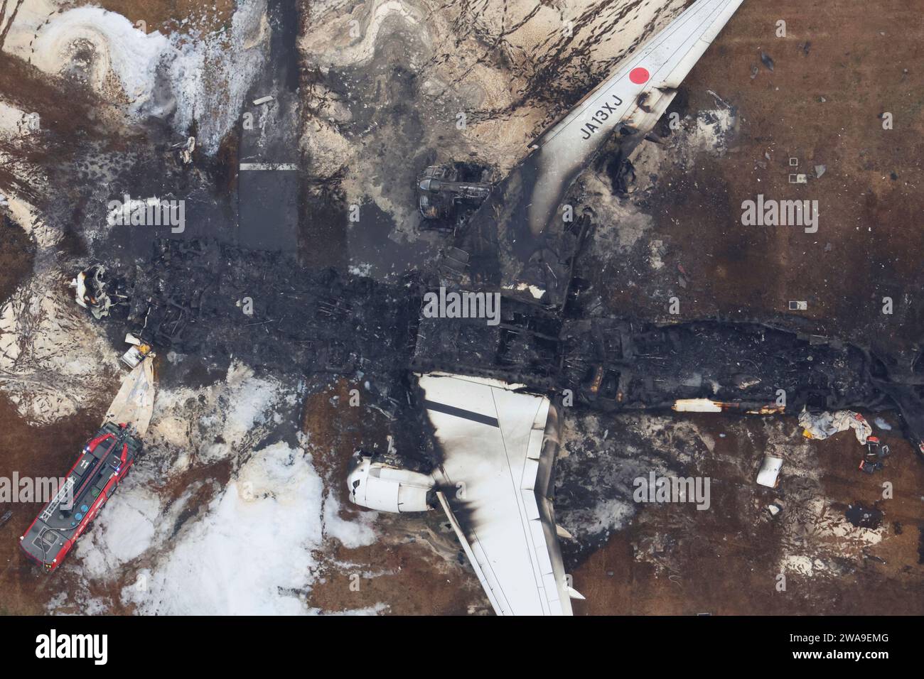An aerial photo shows Japan Airlines flight 156 burnt on the runway at ...