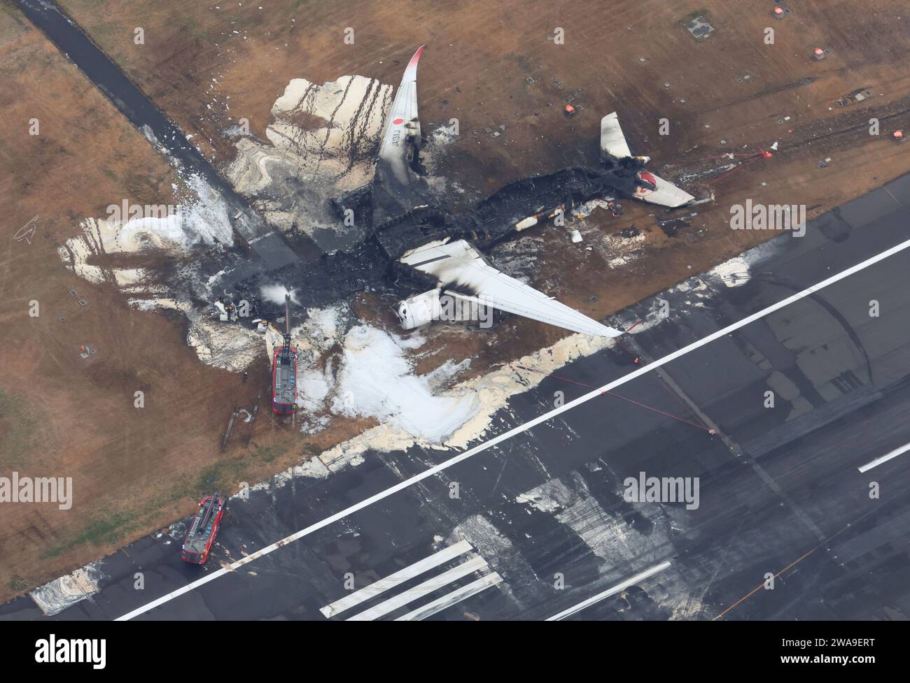 An aerial photo shows Japan Airlines flight 156 burnt on the runway at ...