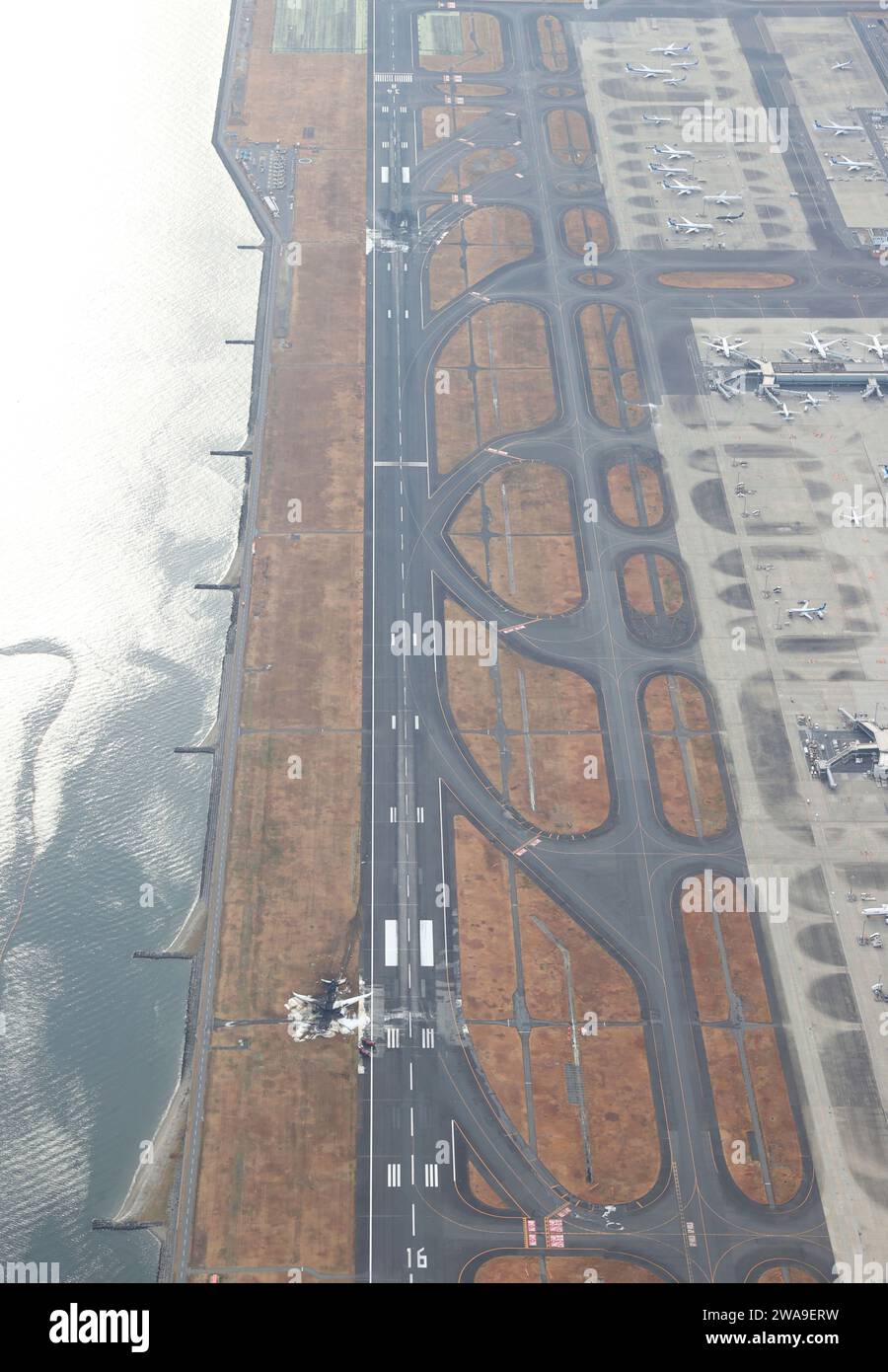 An aerial photo shows Japan Airlines flight 156 (bottom) and a Japan ...