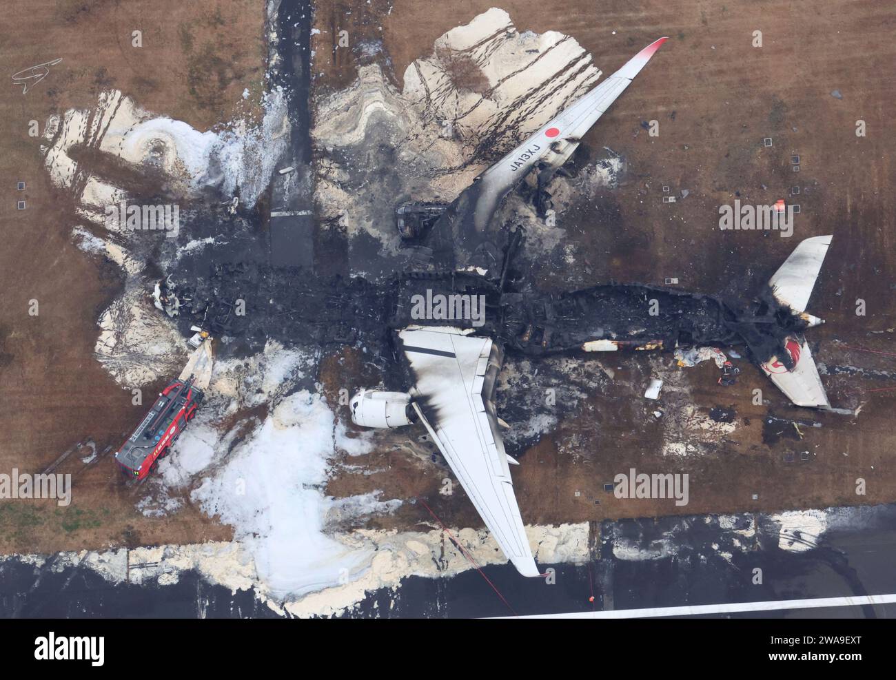 An aerial photo shows Japan Airlines flight 156 burnt on the runway at ...