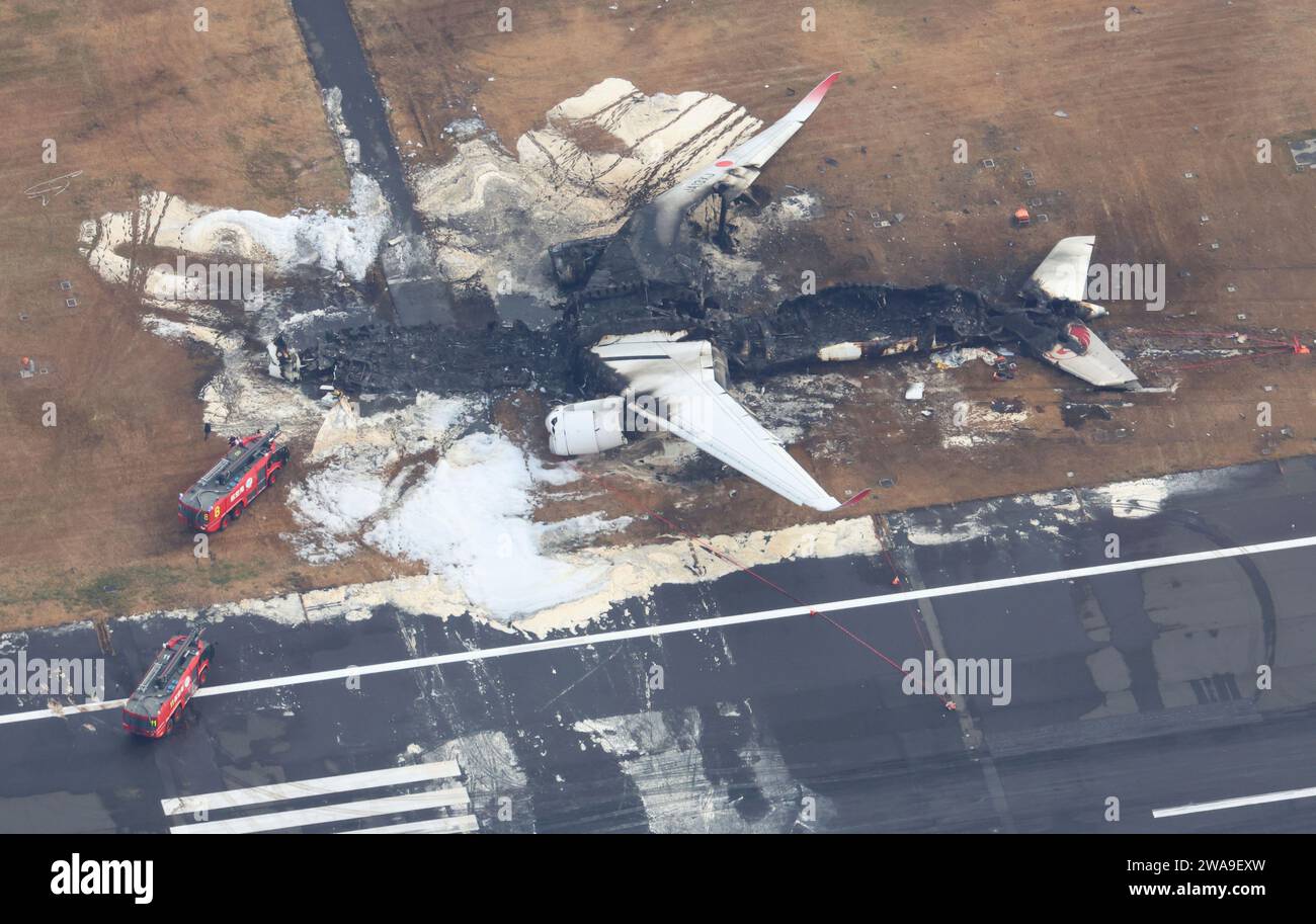 An aerial photo shows Japan Airlines flight 156 burnt on the runway at ...
