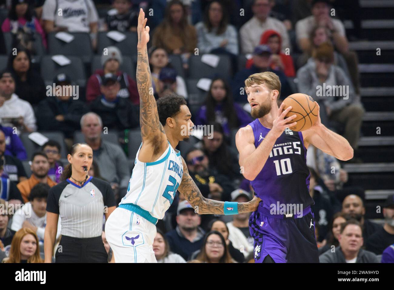 Charlotte Hornets forward P.J. Washington, left, guards Sacramento Kings forward Domantas ...